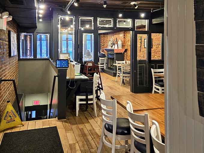 Exposed brick walls and natural light streaming through tall windows create an inviting space for leisurely dining.