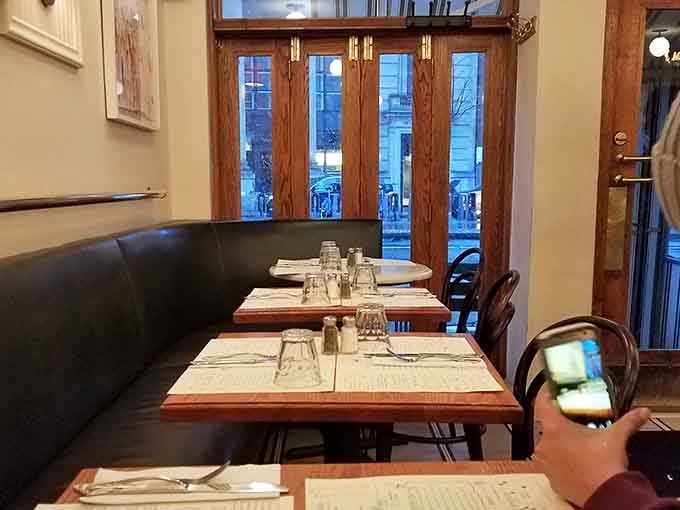 Cozy banquette seating by tall wooden doors. This corner table has witnessed a thousand great conversations.
