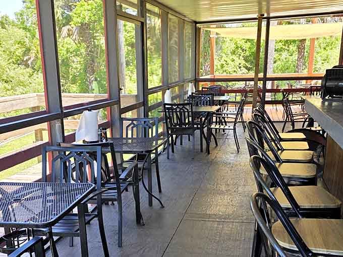 The screened porch overlooks pure Everglades greenery, making every bite feel like a nature documentary bonus scene.