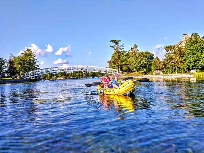 Two paddlers, one bright yellow kayak, and a graceful footbridge overhead. This is the kind of afternoon that makes you forget your phone exists.