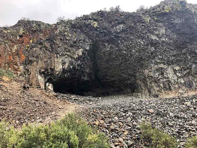 The mouth of the cave yawns open, inviting you into shadows that have sheltered humans for millennia.