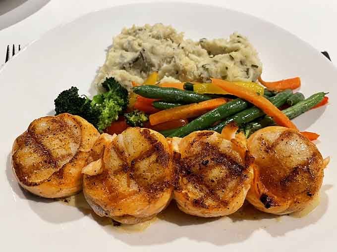 Four perfectly seared scallops lined up like a delicious chorus line, ready to steal the whole show.