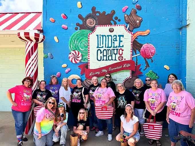 A whole group dressed for candy, gathered under a mural that perfectly captures the spirit here.