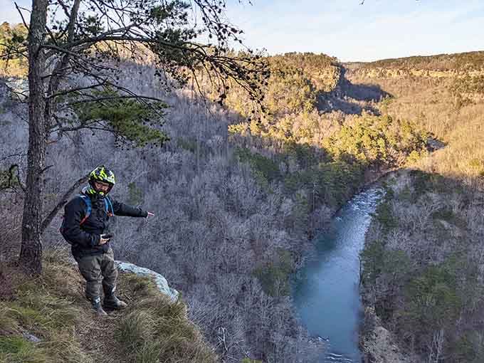 A motorbike rider gestures toward the canyon below as if to say, "Yeah, I found this first."