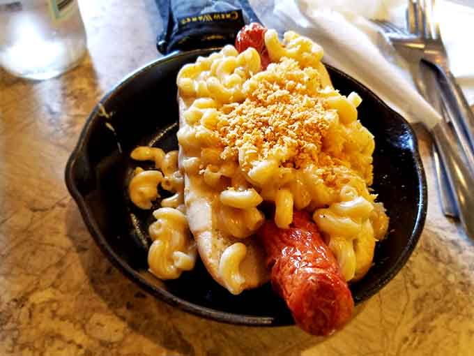 A hot dog smothered in mac and cheese represents everything beautiful about American culinary innovation and excess.