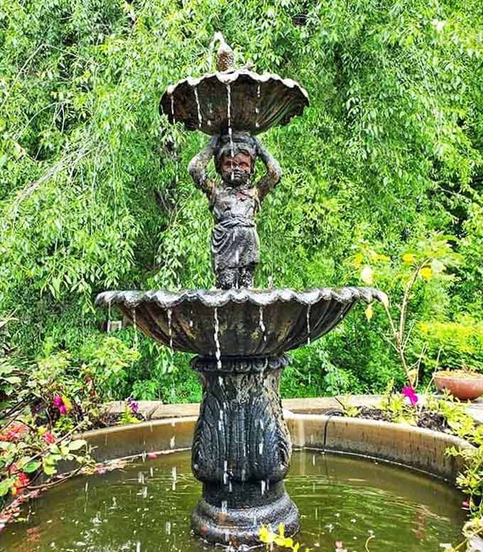 A classical fountain adds old-world charm to this decidedly tropical setting, creating unexpected visual harmony.