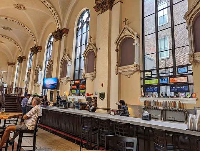 A long bar stretching beneath Gothic details is where miracles happen, one pour at a time.