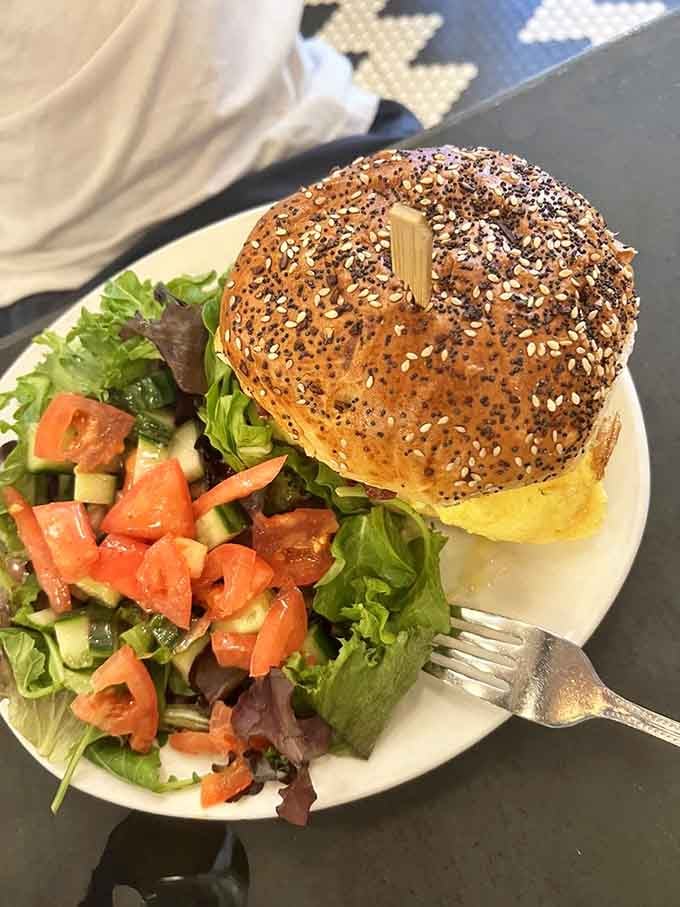 A toasted everything bagel stuffed with egg and cheese, served with a fresh salad. New York mornings, done right.