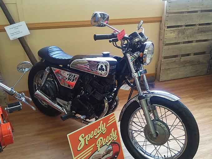 This sleek black cafe-style motorcycle with its "Speedy Peedy" sign is basically the coolest thing in any room it occupies.