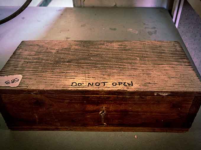 A wooden box labeled "Do Not Open" sitting in an abandoned asylum is either deeply symbolic or deeply terrifying, possibly both.