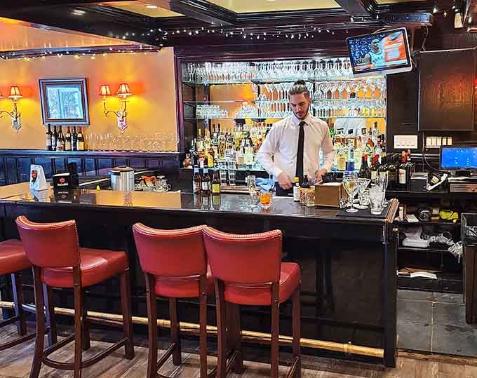 A focused bartender, rows of gleaming glassware, and warm amber lighting make this bar a destination all on its own.