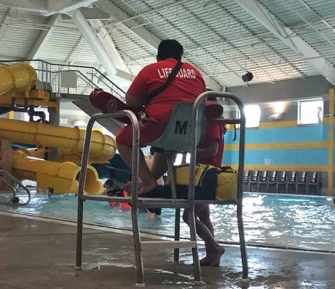 A vigilant lifeguard watches over the indoor pool. Safety and fun, working together beautifully at Pelican Harbor.