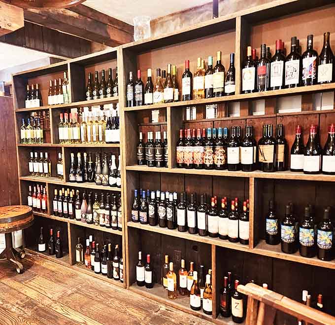 Floor-to-ceiling wine shelves built from aged wood. Choosing a bottle here feels like a treasure hunt worth winning.
