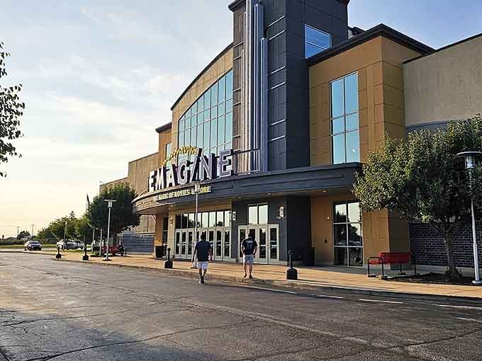 Two people walking toward Emagine Portage at golden hour proves that some movie nights deserve a genuinely grand entrance.