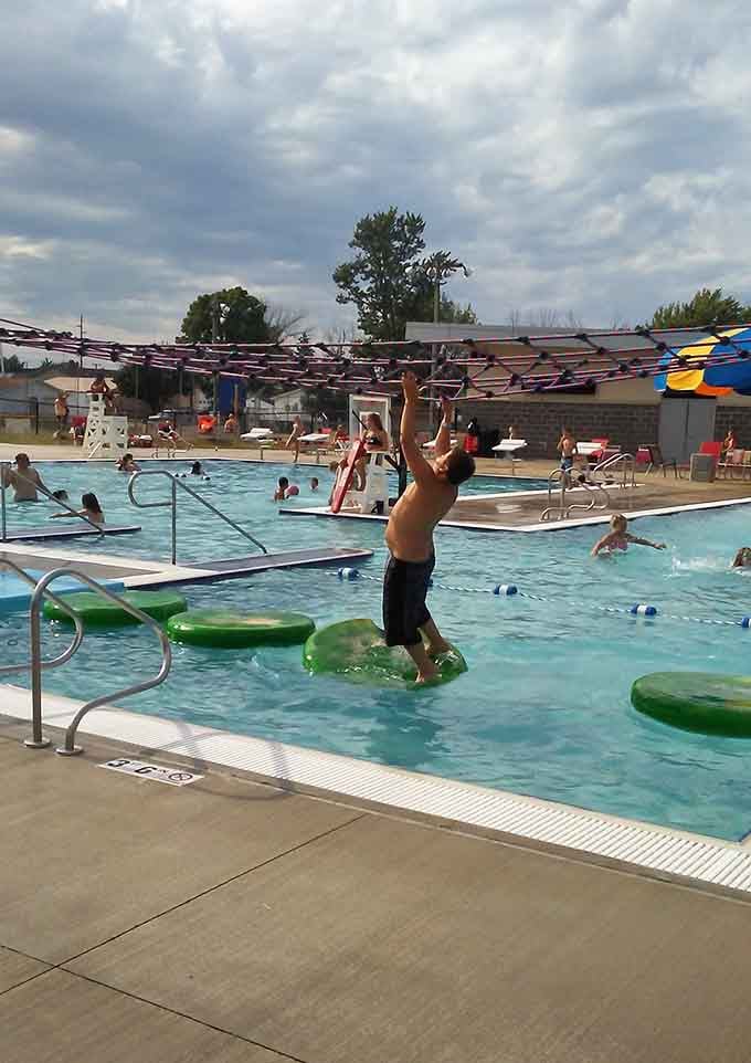 Balancing across floating green pads while trying not to fall in is the kind of challenge that makes everyone laugh, including the person falling.