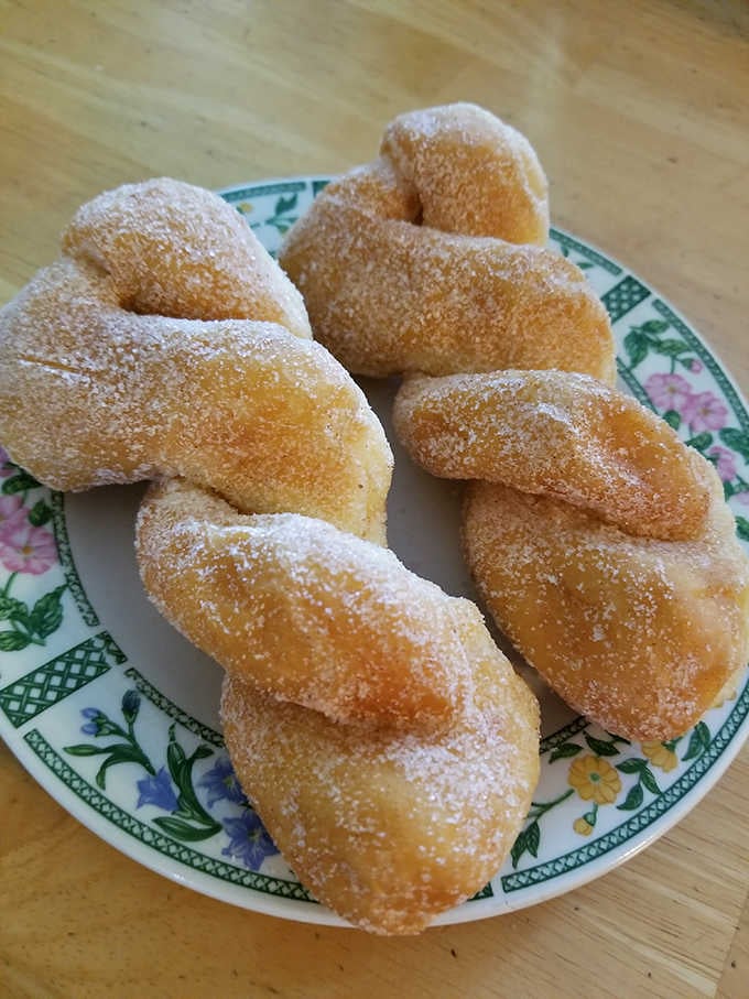 Twisted donuts dusted with cinnamon sugar, looking like they just won the lottery and can't stop smiling about it.