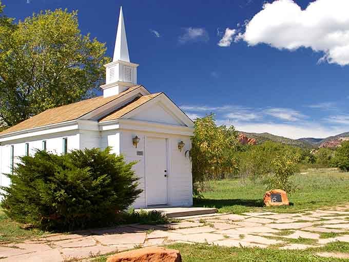 A little white chapel with a steeple, sitting against red rocks like a postcard that never got mailed.