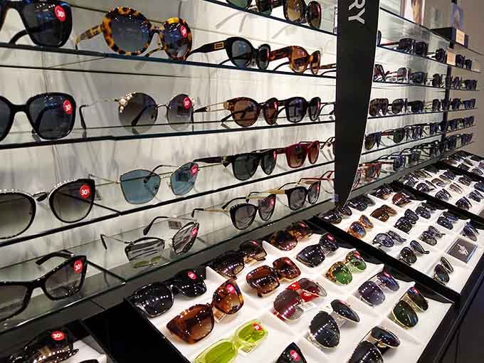 A wall of designer sunglasses with discount tags attached. Looking this cool has rarely been this affordable.