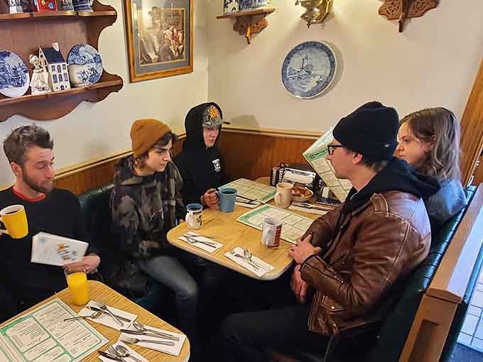 Happy diners gathered around tables, sharing laughs and great food, this is community at its finest.