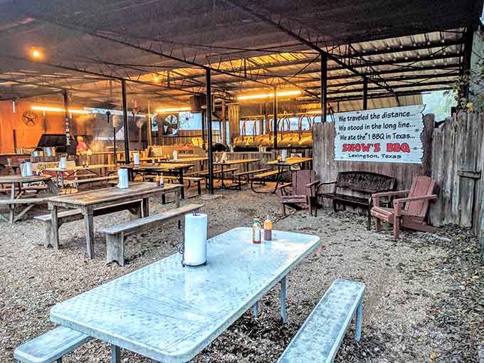 Picnic tables, gravel underfoot, and a sign on the wall that says everything worth saying about this place.