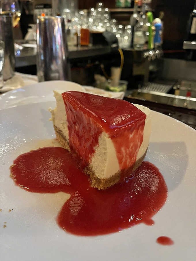 Creamy cheesecake with a vivid berry sauce, the kind of dessert that makes you forget you just ate a steak.
