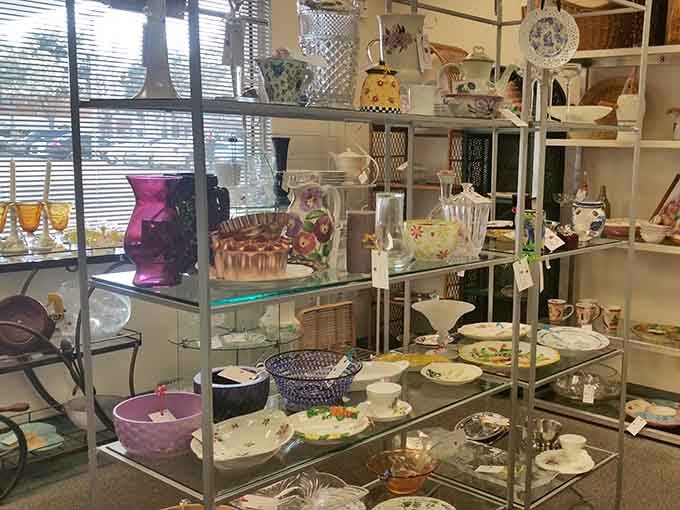 Glass shelves showcase everything from purple vases to delicate teacups like a proper antique shop display.