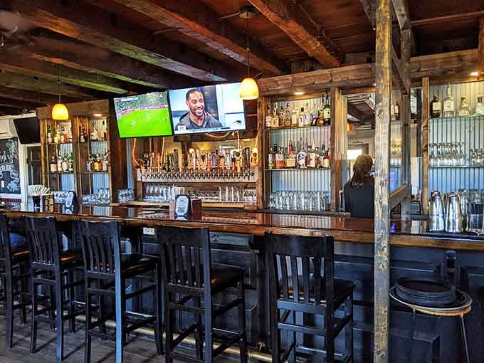 A well-stocked bar with a row of taps, warm pendant lights, and a game on the screen, honestly, what more do you need.