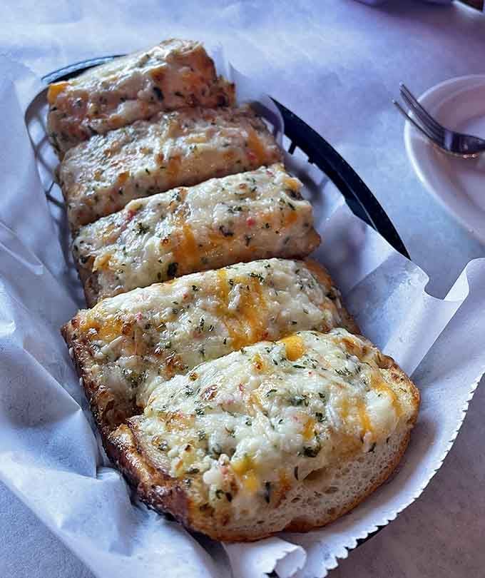 Cheesy, herb-topped bread that looks like it was pulled straight from a coastal grandmother's kitchen. Nobody's leaving a single slice behind.