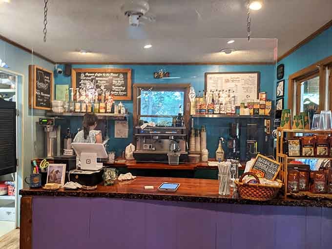 Behind this warm wooden counter, good coffee is made with care, and the teal walls make the whole thing feel like an adventure.