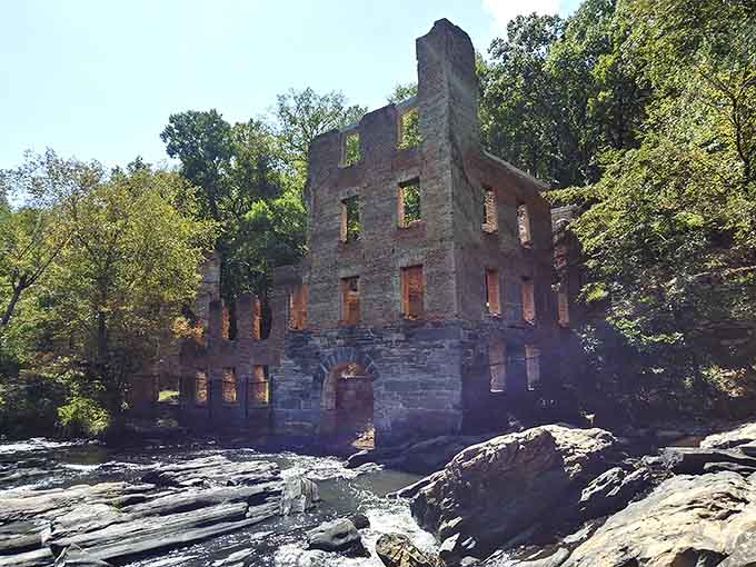 Standing at creek level, the mill rises above the water like a monument that simply refused to disappear.