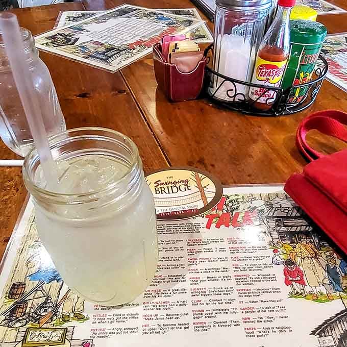 A frosty mason jar drink beside the Swinging Bridge menu placemat. Even the table setting here tells a good story.