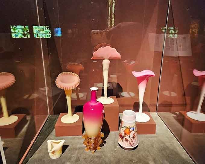 Trumpet-shaped art glass vases rising like elegant flowers from their pedestals remind you that even a display case can feel like a garden.