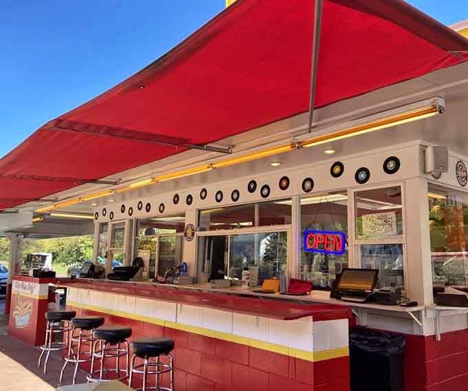 Vinyl records on the wall, counter stools lined up, and a neon open sign that feels like a personal invitation.