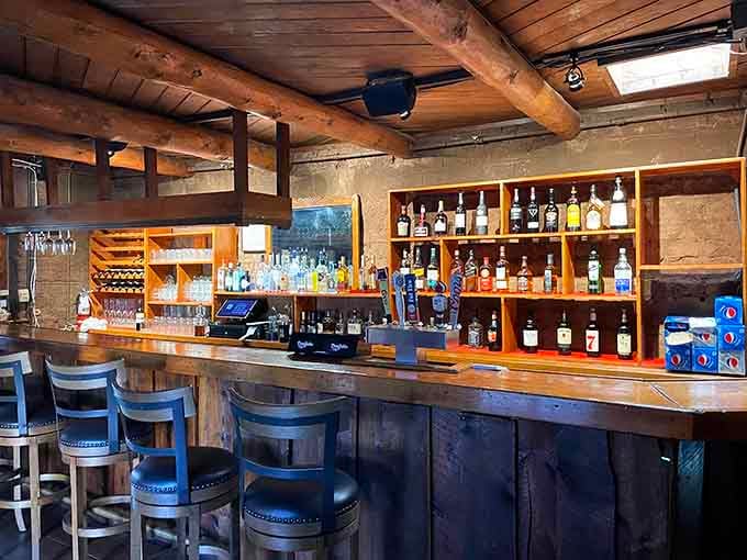 Rough-hewn log beams, warm wood shelves, and a full bar. This is exactly where a mountain man would order a cocktail.