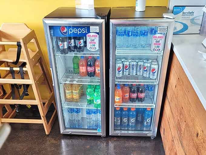 Those glass-front coolers stocked with cold beverages stand ready to complement your hot, cheesy meal with refreshing precision and style.