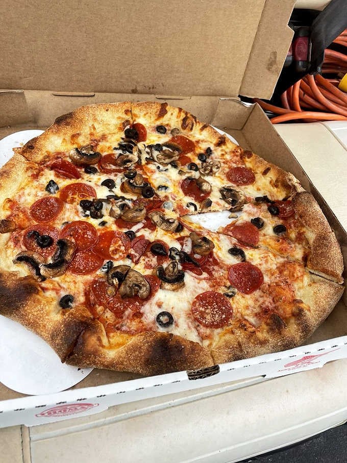 A proper pizza with pepperoni, mushrooms, and olives, golden-crusted and generous, straight out of a beach town dream.