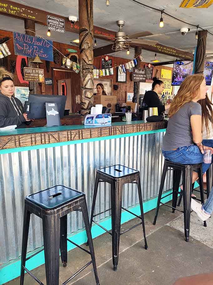 Corrugated metal bar front, teal accents, and handwritten signs, this bar area has personality packed into every single inch.