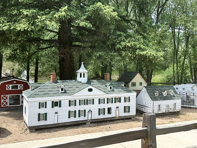 A stately white colonial manor with green shutters sits beneath towering redwoods, looking like Mount Vernon took a Colorado vacation.