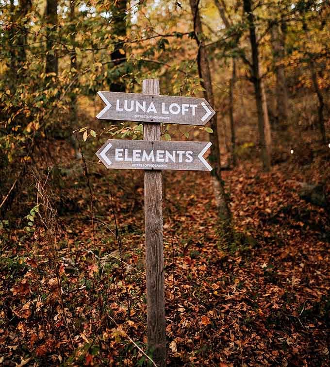 A wooden signpost pointing toward Luna Loft and Elements, because even getting lost here comes with charming directions.
