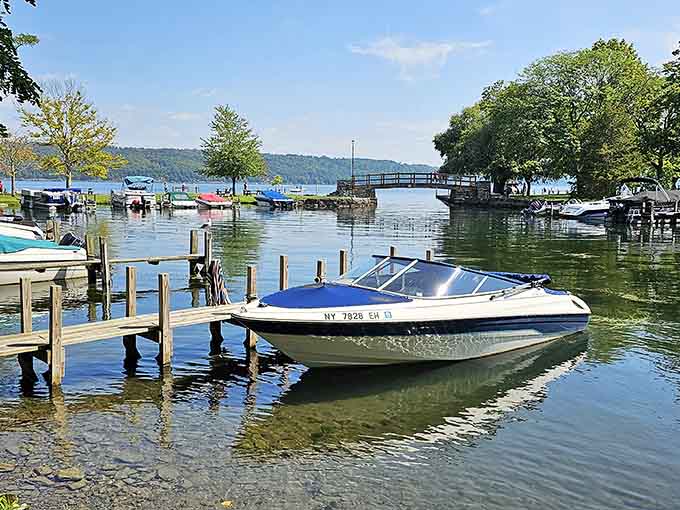 Clear green water, a wooden dock, and a blue-hulled boat that's basically daring you to untie it and see where the afternoon goes.