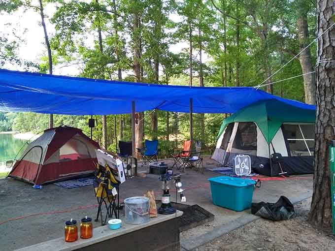 Two tents, a blue tarp canopy, and a campsite that says the whole crew showed up and meant business.