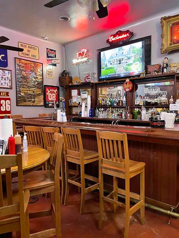 A bar area covered in Chiefs memorabilia and neon signs. Cold drinks, warm atmosphere, and a TV that knows its audience.