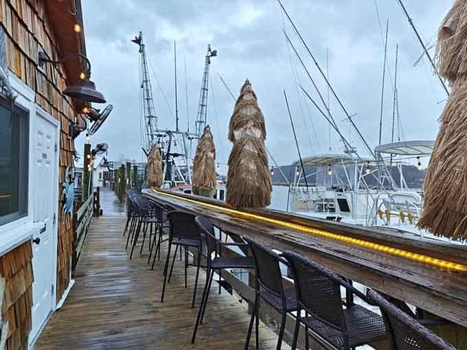 A dock lined with bar seating and fishing boats right behind you. Dinner with a view, no reservations needed.