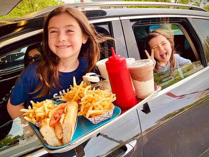 Two kids, one tray full of fries and shakes, and zero complaints. This is what a perfect outing looks like.