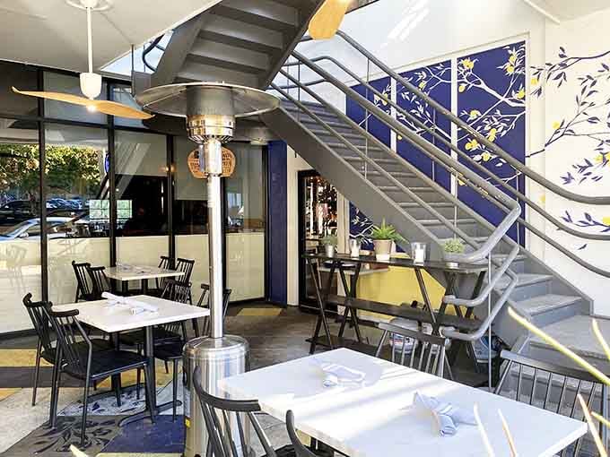 The outdoor staircase leads upward past a gorgeous botanical mural, making even the walk to your table an experience.