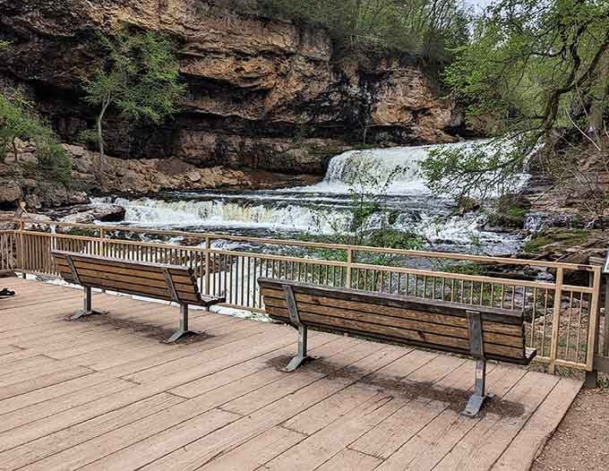 Two wooden benches face Willow Falls from the viewing platform, offering the rare luxury of sitting down while nature does all the work.