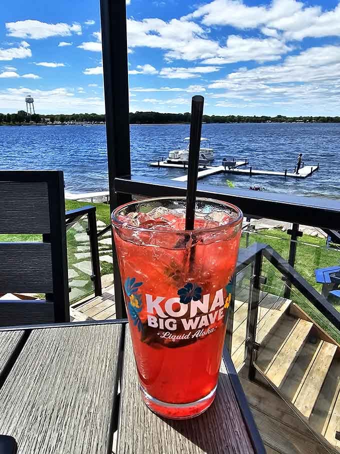 A bright red drink, a dock in the distance, and a sky that's showing off. Minnesota summers, fully justified.