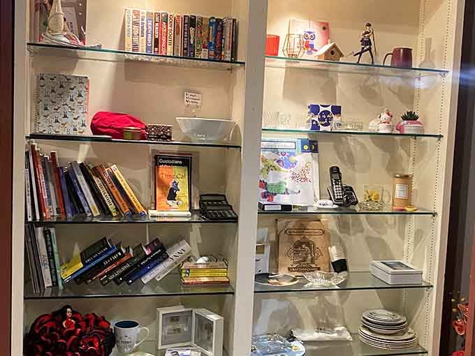 Books, trinkets, mugs, and curiosities tucked into glass shelves. Every single item here has a story worth hearing.