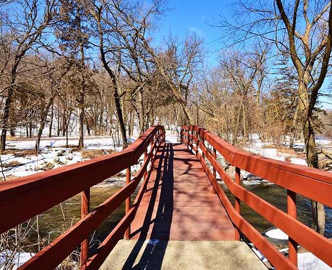 That bold red bridge cutting across a snowy winter landscape is Ramsey Park saying hello in its most dramatic voice.