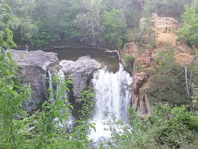 Framed by lush green trees, this waterfall tumbles into a rocky gorge like nature showing off just a little.